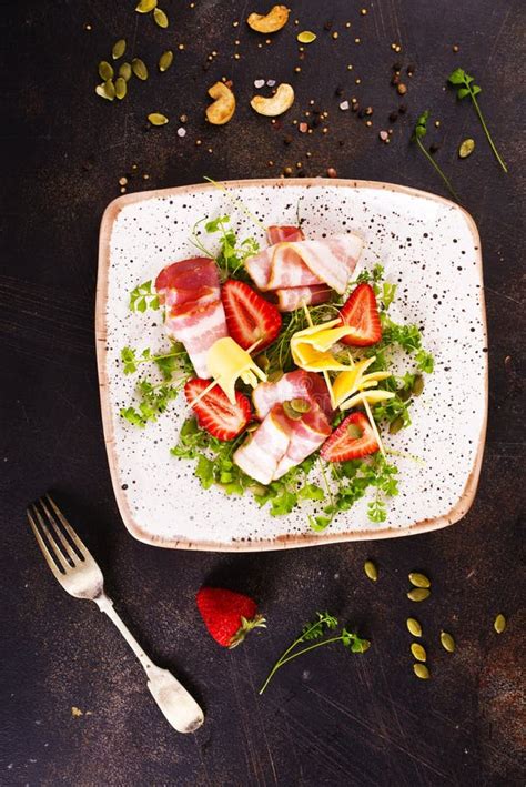 Assorted Cheeses And Prosciutto With Strawberry On Plate Stock Image
