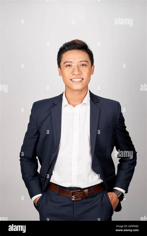 A Young Asian Man In Suit Put Both Hands In His Pants Pocket Isolated