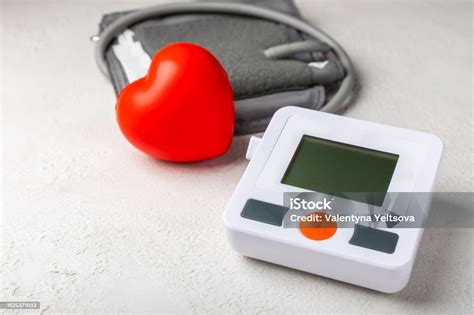 혈압계와 장난감 심장은 하얀 질감의 배경에 있다 의학 개념입니다 건강 관리 및 의학 텍스트를 위한 위치입니다 복사를 위한