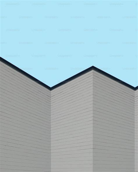 푸른 하늘을 배경으로 건물 위를 날고 있는 비행기 사진 Unsplash의 건물 이미지