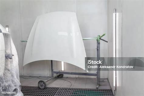 특수 챔버에서 자동차를 그림에 대 한 워크샵에서 특수 홀더에 장착 퍼 티의 도움으로 사고 후 흰색 차의 큰 후드의 수리 밝은 조명과 함께 부스 스프레이 가리기에 대한 스톡