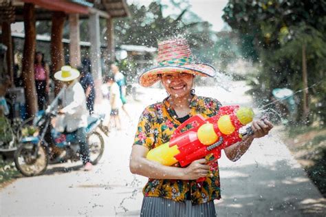 Premium Photo Portrait Of Smiling Woman Holding Squirt Gun