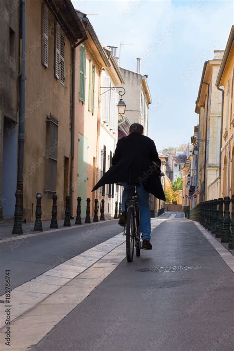 Bicyclist On Narrow Street With Pastel Colored Stucco Buildings On