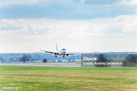 흐린 하늘을 배경으로 그단스크 레흐 바웬사 공항의 활주로에 착륙하는 하얀 비행기의 다이나믹한 샷 0명에 대한 스톡 사진 및 기타 이미지 Istock