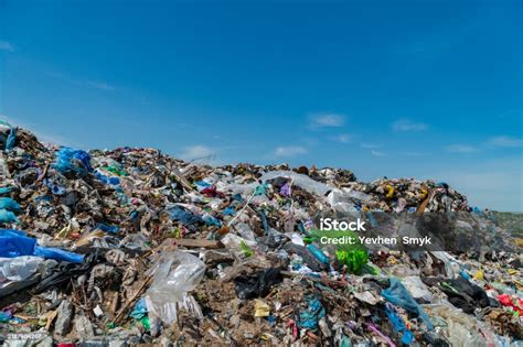쓰레기와 플라스틱 쓰레기로 넘쳐나는 광대한 매립지는 밝고 푸른 하늘과 극명한 대조를 이루며 생태계에 영향을 미치는 폐기물 관리 및 오염의 중요한 문제를 강조합니다 쓰레기