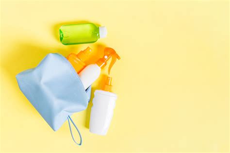 선크림 스프레이 선스린 선블록 바디 로션 Spf 크림이 가득한 여성 화장품 가방의 탑 뷰를 복사 공간이 있는 노란색 배경에 있습니다 바로 위의 밝은 여름 컨셉 여름에 대한