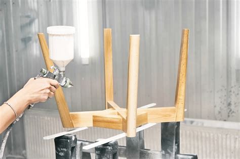 여자는 페인트 챔버에 스프레이 총으로 나무 의자 베이스를 페인트 가구에 대한 스톡 사진 및 기타 이미지 가구 스프레이