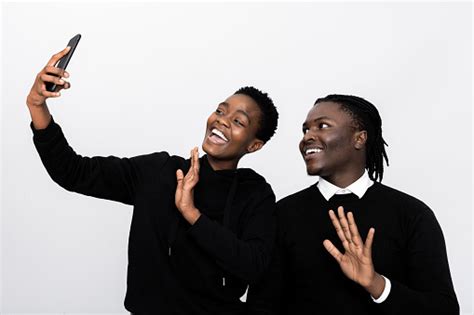 행복한 아프리카계 미국인 여성과 스튜디오에서 하얀 배경 위에 고립되어 사진 셀카를 찍고 촬영 과정에서 함께 시간을 보내는 것을 즐긴다 아름다운 흑인 커플 관계 2명에 대한