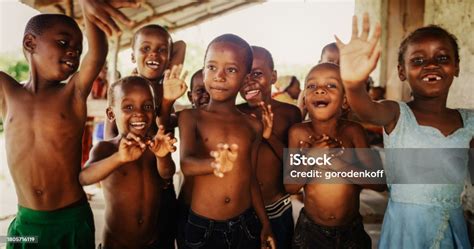 시골 지역에서 웃고 점프하고 손을 흔드는 아프리카 어린이 그룹 기쁨으로 삶을 축하하는 흑인 아이들 카메라는 어린 시절의 아름다움과 본질 마을에 사는 순수함과 순수함을