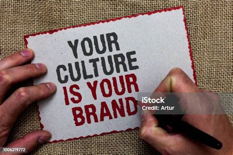 단어 텍스트 당신의 문화는 당신의 브랜드를 쓰기입니다 지식 경험에 대 한 비즈니스 개념은 황 지상 인간의 손으로 빨간 테두리가 종이에 일부 텍스트를 작성 한 프레 젠 테이