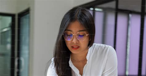 여성 노동자의 초상화는 사무실에서 나무 테이블에 노트북으로 서서 일하고 있다 사진 Unsplash의 랩톱 이미지