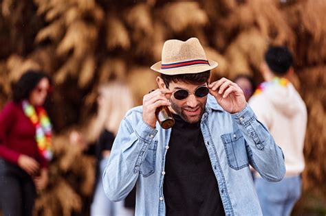 선글라스와 모자를 쓴 남자가 야외에서 파티를 하는 동안 맥주병을 들고 있다 18 19세에 대한 스톡 사진 및 기타 이미지 18 19세 25 29세 30 34세