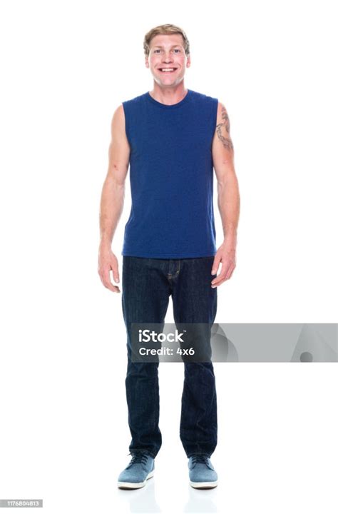 전체 길이 정면 1명 2029세 성인 잘생긴 사람 코카서스 남성 젊은 남성 서 탱크 탑 청바지 바지 캔버스 신발 웃고 있는 행복 쾌활 한 웃음 시원한 태도 20 29세에