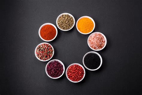 질감이 있는 콘크리트 배경의 흰색 세라믹 그릇에 다양한 종류의 향신료로 구성된 구성 프리미엄 사진