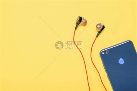 黄色背景上带红色耳机的蓝色智能手机极简主义风格从顶部高清图片下载 正版图片505881279 摄图网