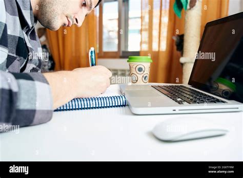 Man Writing In A Notebook While Using A Computer Stock Photo Alamy