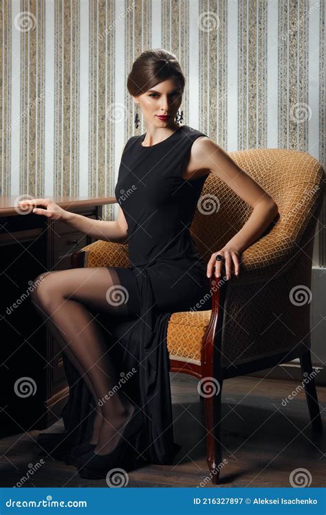 Gorgeous Lady In Elegant Evening Black Dress With Deep Cut In Stockings