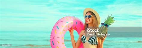 바다 배경의 해변에서 밀짚 모자를 쓰고 풍선 반지와 파인애플을 가진 행복한 미소 짓는 젊은 여성의 초상화 20 29세에 대한 스톡 사진 및 기타 이미지 Istock