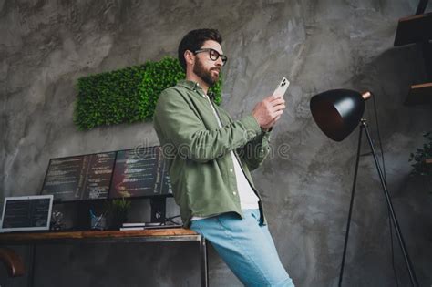 Portrait Of Professional Hacker Young Man Use Smart Phone Computer Desk Loft Interior Office