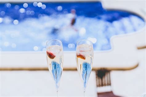 햇볕이 잘 드는 테라스 야외 테라스는 여름 날 도시의 바깥에 수영장을 내려다에 딸기와 함께 두 개의 아름 다운 샴페인 유리 근접 촬영 볼 수 있습니다 0명에 대한 스톡 사진