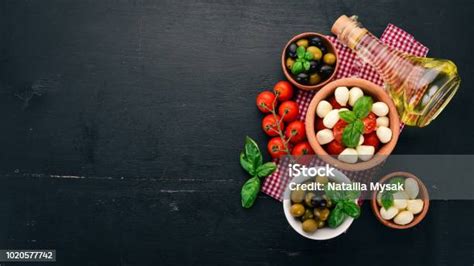 이탈리아 Caprese 샐러드 재료입니다 모 짜 렐 라 치즈 체리 토마토 바 질 잎 올리브 오일 후추 에 검은 나무 배경 텍스트에 대 한 여유 공간입니다 0명에 대한 스톡