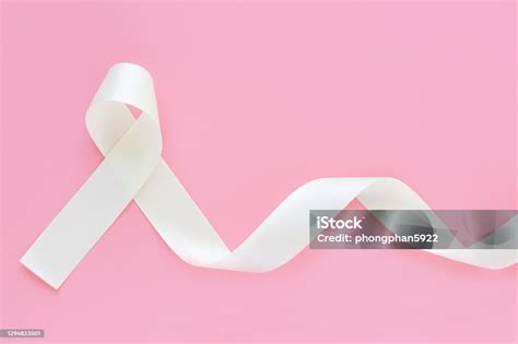 복사 공간이있는 분홍색 고립 된 배경에 흰색 진주 리본 컬 폐암 인식 중피종 및 망막 모세포종 암 기호 여성에 대한 반폭력 안전한 모성에 대한 순수성 표지판 리본상에 대한
