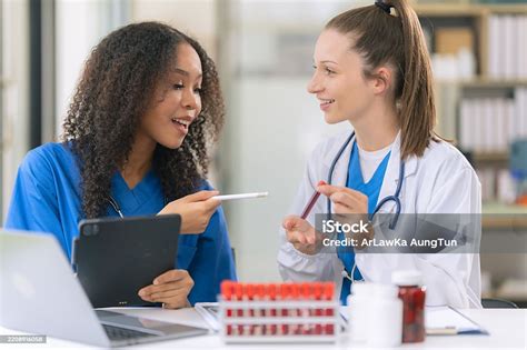 두 명의 여성 과학자가 현대식 실험실의 시험관에서 액체를 검사하고 특수 보호복을 입은 채 화학 물질과 실험 물질을 정밀하게 취급합니다 2명에 대한 스톡 사진 및 기타 이미지