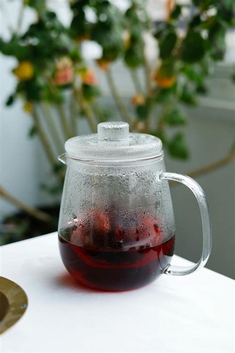 테이블 위의 허브 티가 담긴 유리 찻주전자 · 무료 스톡 사진