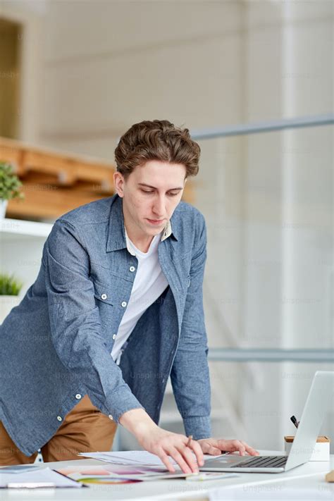 패턴으로 작업하고 사무실에서 노트북을 사용하는 진지한 디자이너 사진 Unsplash의 테이블 이미지