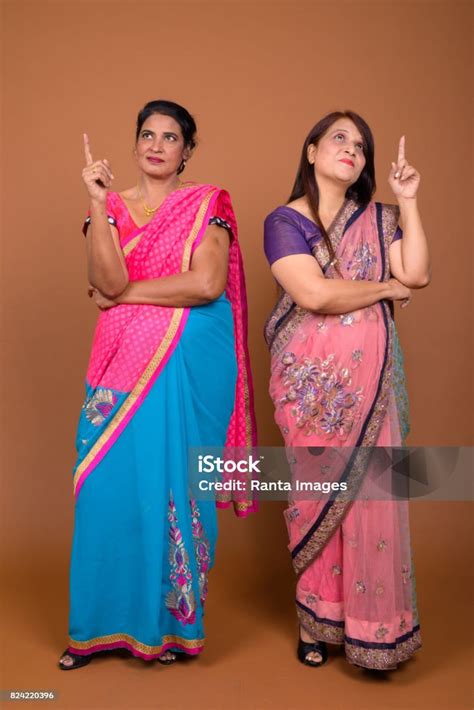 두 스튜디오 샷 성숙 착용 사리 인도 전통 옷 색깔 배경 함께 인도 여성 2명에 대한 스톡 사진 및 기타 이미지 2명 40 49세 45 49세 Istock