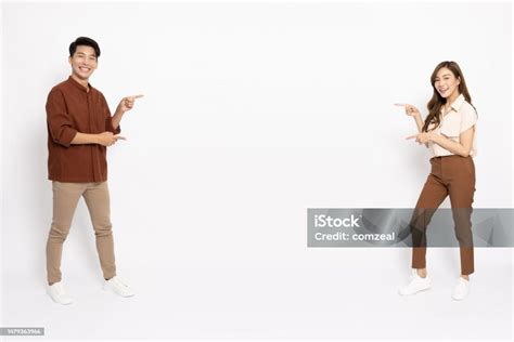젊은 아시아 커플이 서서 흰색 배경에 고립된 빈 복사 공간을 가리키고 있다 두 사람 개념 2명에 대한 스톡 사진 및 기타 이미지 2명 가리키기 광고 Istock
