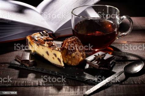 달콤한 점심입니다 차 노트북 및 나무 배경에 케이크의 컵 개미 집 케이크 그리고 어두운 돌 접시에 연유와 초콜릿 치즈 케이크 낮은 키입니다 개미 집에 대한 스톡 사진 및