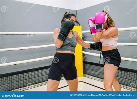 Boxer Giving A Low Blow To Her Colleague Who Are Practicing In The Ring