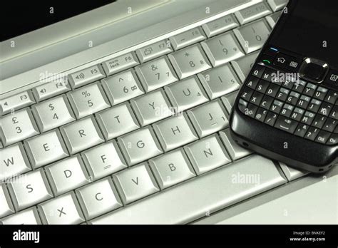 Close Up Image Of A Laptop Computer Keyboard And A Modern Mobile Cell Telephone Stock Photo Alamy