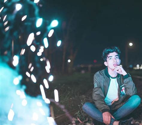 A Man Sitting On The Ground In Front Of Some Lights
