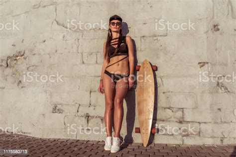 수영복 여름 도시에서 소녀는 벽 일광욕 선글라스를 스탠드 스케이트 보드 스포츠 피트니스 후 휴식 운동 긴 머리를 가진 무두질 그림 야구 모자 스포츠 슬림 피규어 롱 보드