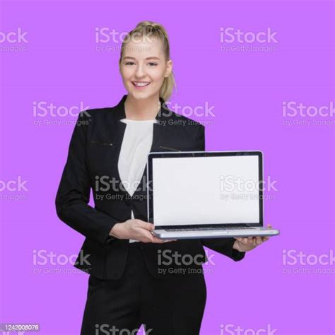 보라색 배경 앞에 서있는 백인 여성 사업가가 비즈니스 웨어를 입고 컴퓨터를 사용 20 24세에 대한 스톡 사진 및 기타 이미지 20 24세 20 29세 금발 머리