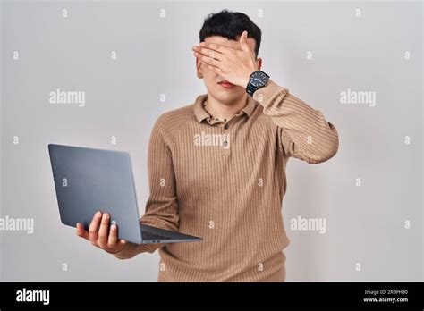 Non Binary Person Using Computer Laptop Covering Eyes With Hand