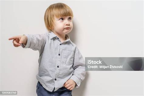 측면에 손가락을 가리키는 흰색 벽 앞에 서있는 작은 백인 소년의 절반 길이 초상화 복사 공간이있는 작은 아이 스튜디오 초상화 2