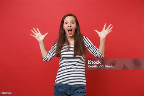 입 벌리고 유지 충격된 젊은 여자의 초상화 보고 놀라게 하 고 밝은 빨간 벽 배경에 고립 손을 확산 사람들이 진심으 감정 라이프 스타일 개념 복사 공간을 비웃는 다 갈색