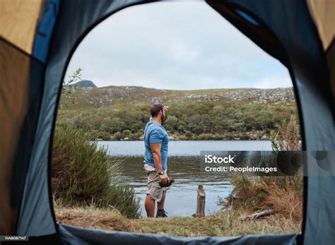 텐트 전망 야외 및 캠핑에서 자연 속에서 모험 휴가 또는 휴가를 즐길 수 있는 호수 옆의 남자 탐험가 쌍안경 및 아침 강 댐 또는 물로 자연 휴식 휴식 또는 휴양지 관광
