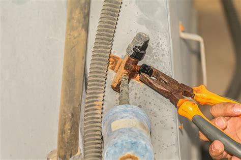 전문 전기 기술자는 지붕 상단에 무거운 의무 에어컨 단위의 전기 공급의 중요한 문제를 해결하고 파란색 유니폼과 모자를 착용하고 도시는 배경에 Stem 주제에 대한 스톡 사진