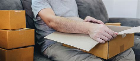 배송을위한 중소기업 소포 집에서 소파에 앉아있는 동안 소포와 온라인 쇼핑 패키지 상자를 여는 해피 맨 고객에 대한 스톡 사진 및 기타 이미지 Istock