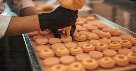 재능 있는 페이스트리 셰프가 베이킹 트레이의 모든 마카롱에 착빙을 짜내는 자른 사진 사진 Unsplash의 증권 시세 표시기 이미지