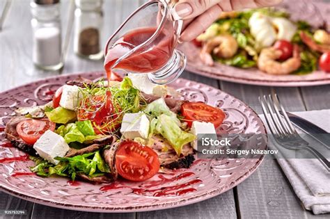 건강 한 혼합된 그리스 샐러드 선명 하 고 잎이 많은 채소 Microgreen 죽은 태아 양파 토마토를 포함 하는 실버 포크로 분홍색 접시에 봉사 하 고 쇠고기 슬라이스 0