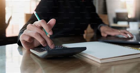 사업가 또는 회계사가 재무 데이터 보고서 회계 문서 및 사무실에서 노트북 컴퓨터를 계산하기 위해 계산기로 작업하는 연필을 들고 있는 클로즈업 비즈니스 개념 사진