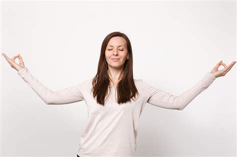 눈을 감고 가벼운 옷에 편안한 젊은 여자 요가 제스처에 손을 잡고 명상 흰색 배경에 고립 된 휴식 사람들은 진심으로 감정 라이프 스타일 개념입니다 복사 공간을 모의 합니다