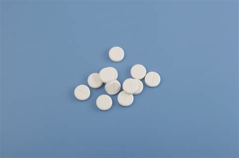 파란색 배경에 고전적인 둥근 흰색 정제입니다 전통 의학 개념 약물 항우울제 및 진정제 소비 증가 0명에 대한 스톡 사진 및 기타