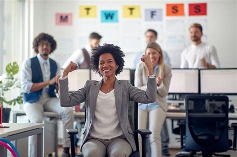 한 젊은 여성 직원이 사무실에서 동료들과 함께 사진을 찍기 위해 포즈를 취하고 있습니다 직원 직장 사무실 20 29세에 대한