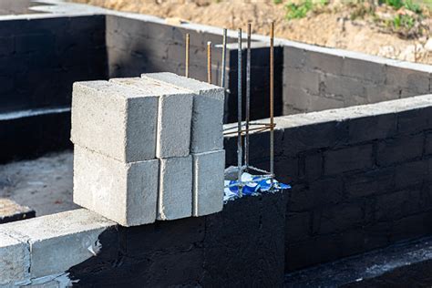 검은 색 분산 아스팔트 고무 덩어리로 칠해진 콘크리트 블록으로 만든 기초 철근 콘크리트 기둥이 보입니다 철근 콘크리트에 대한 스톡 사진 및 기타 이미지 Istock